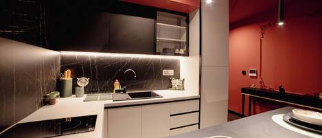 Uma cozinha moderna com esquema de cores preto e branco, forno embutido e pia.