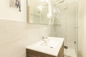 Suíte estúdio superior | Banheiro | Chuveiro, secador de cabelo, toalhas de banho, sabonete