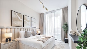 Um quarto moderno com uma cama grande, mesas de cabeceira, um espelho e obras de arte na parede.