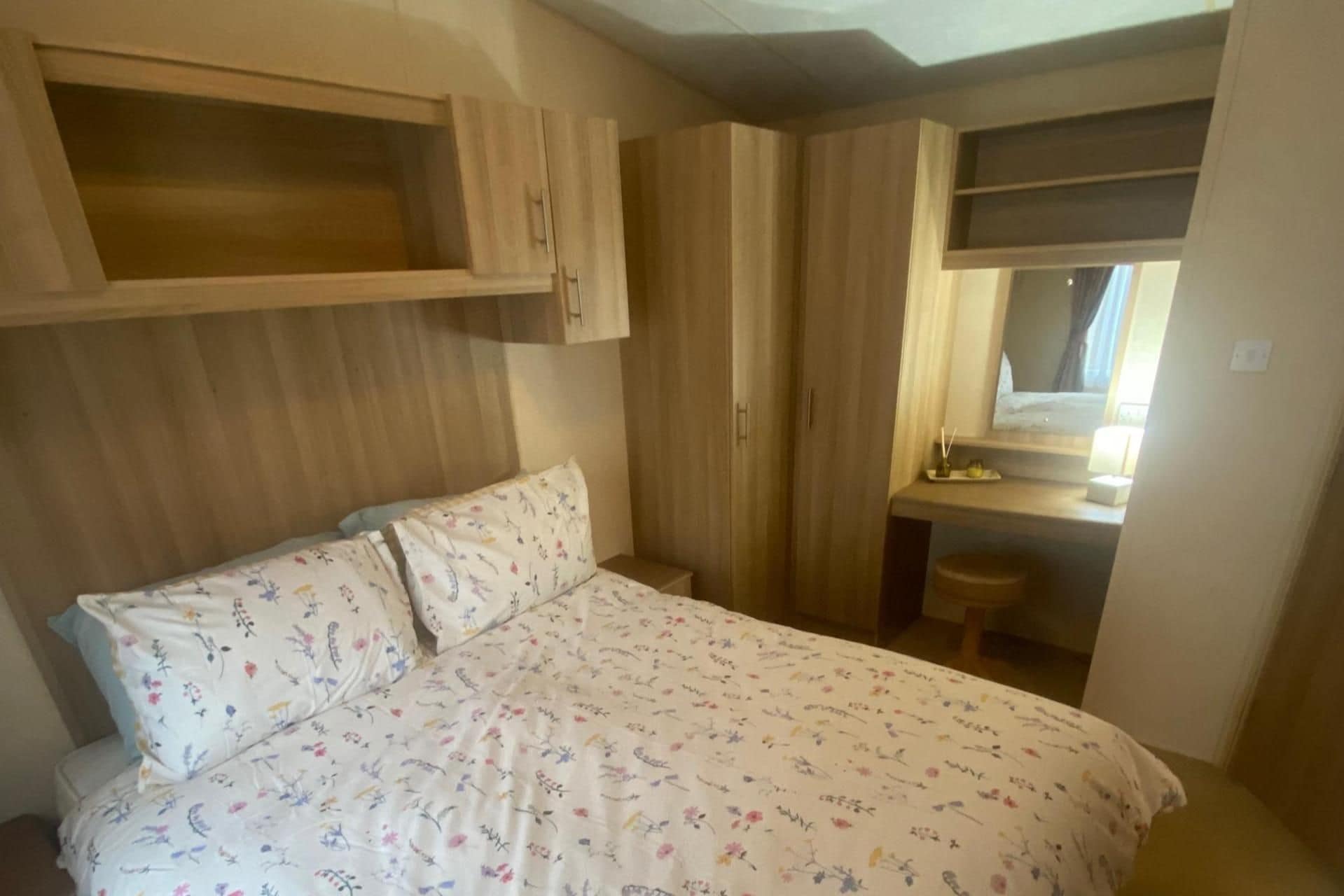 Quarto com cama, guarda-roupa e área de estudo.
