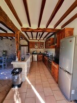 Cozinha com vigas de madeira, geladeira e pia.