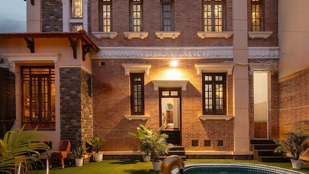 Uma casa grande com piscina e um brinquedo flutuante de pato.