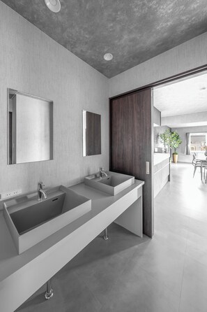 Uma combinação polibã/banheira, um secador de cabelo, chinelos, um bidé 