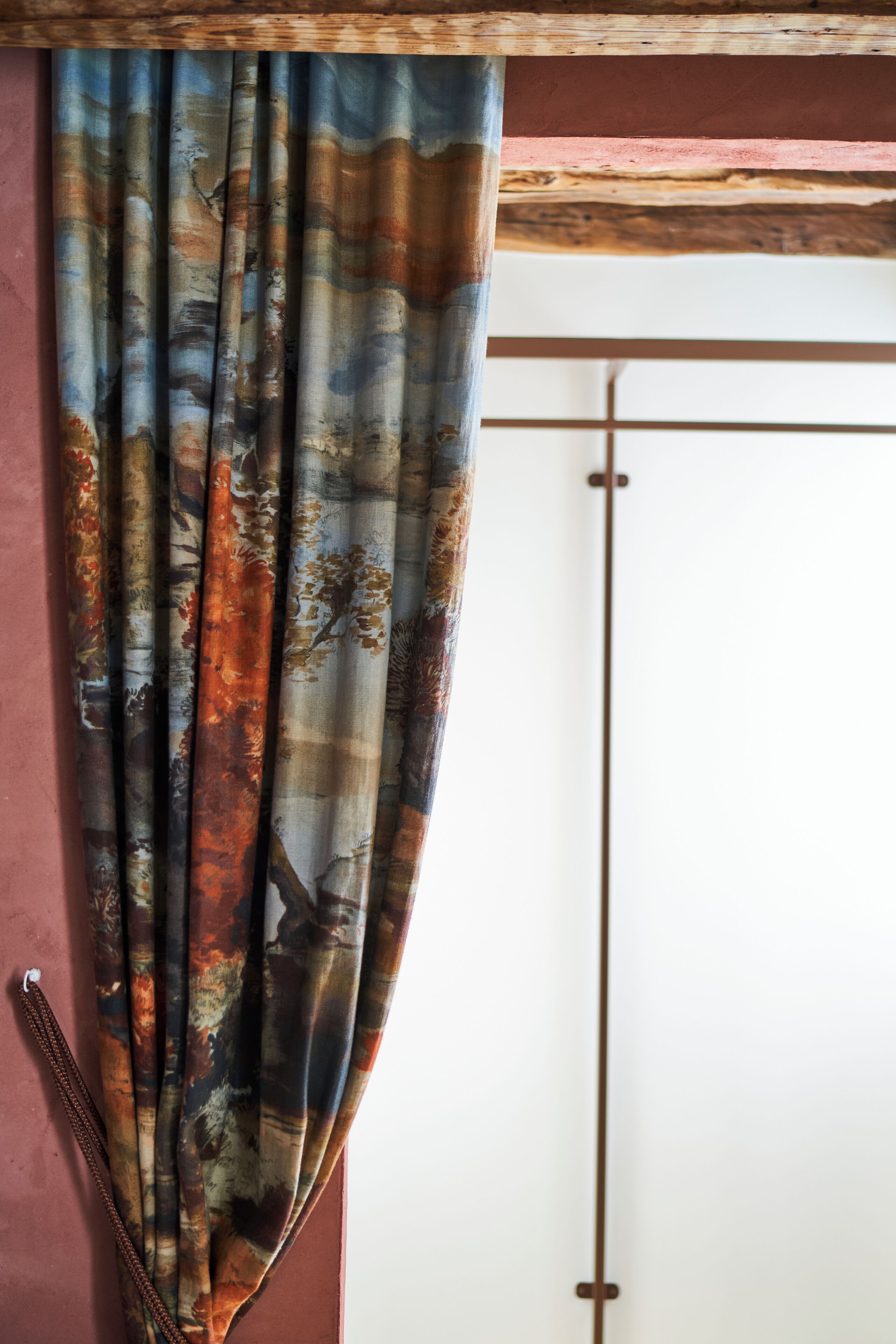 Quarto com teto de madeira e cortina com padrão de tema natural.