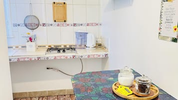 Quarto Triplo Clássico, pátio, vista para o pátio | Kitchenette privada | Um micro-ondas no espaço comum