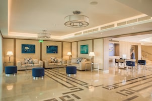 Um lobby amplo com teto alto, móveis modernos e obras de arte nas paredes.