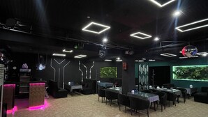 Um espaço amplo e interno, com bar e assentos.