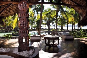 Um cenário de resort tropical com piscina, palmeiras e uma estrutura de telhado de palha.