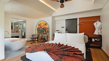 Quarto de hotel moderno com uma cama grande, banheira, ventoinha no teto, guarda-roupa e espelho.