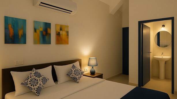 Quarto de hotel com cama, abajur e uma obra de arte na parede.