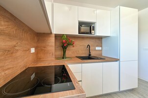 Apartamento Deluxe, varanda, vista parcial para o mar | Cozinha privada | Um frigorífico, um micro-ondas, um forno, uma placa de cozinha 