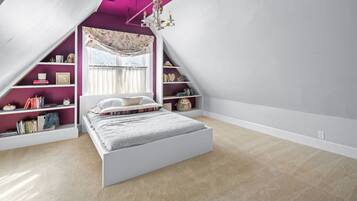 Quarto com teto inclinado, cama com estrutura branca e estantes embutidas com livros e objetos decorativos.
