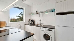Uma cozinha moderna com máquina de lavar embutida, pia e janela com vista para o exterior.