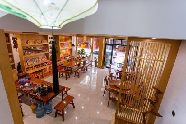 Um espaço amplo e interno com mobiliário de madeira, um guarda-sol grande e prateleiras com diversos objetos.