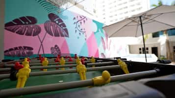 Uma mesa de futebol de mesa com um mural colorido ao fundo.