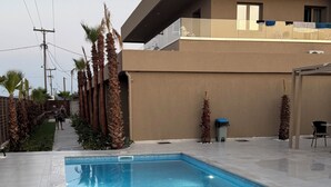 Um edifício moderno com telhado plano e piscina.