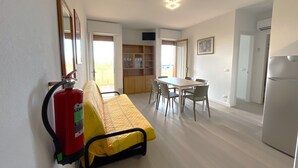 Um espaço compacto com cama, mesa de jantar e cozinha.