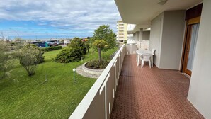 Varanda com vista para uma área gramada e edifícios.
