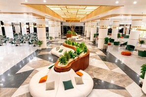Um hall amplo com área de estar central, diversas opções de assento e design moderno.