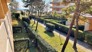 Um bairro residencial com gramado bem cuidado, sebes e árvores.