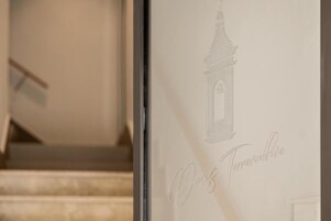 Uma porta de vidro com um desenho arquitetônico discreto de uma torre e o texto 'Chris Tompkins'.
