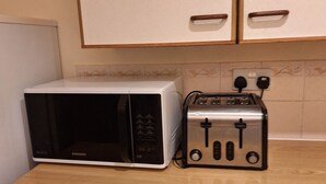 Cozinha com micro-ondas e torradeira na bancada.