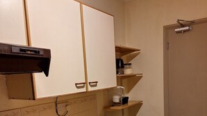 Uma cozinha com fogão, armários e uma porta.