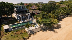 Um resort moderno com piscina, acesso à praia e paisagismo tropical.