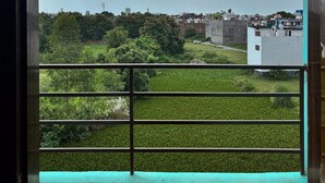 Varanda com vista para um horizonte urbano, incluindo edifícios e áreas verdes.