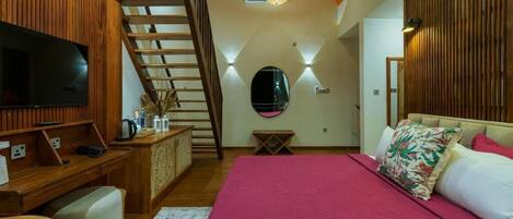 Quarto com cama grande, móveis de madeira, televisão e escada.