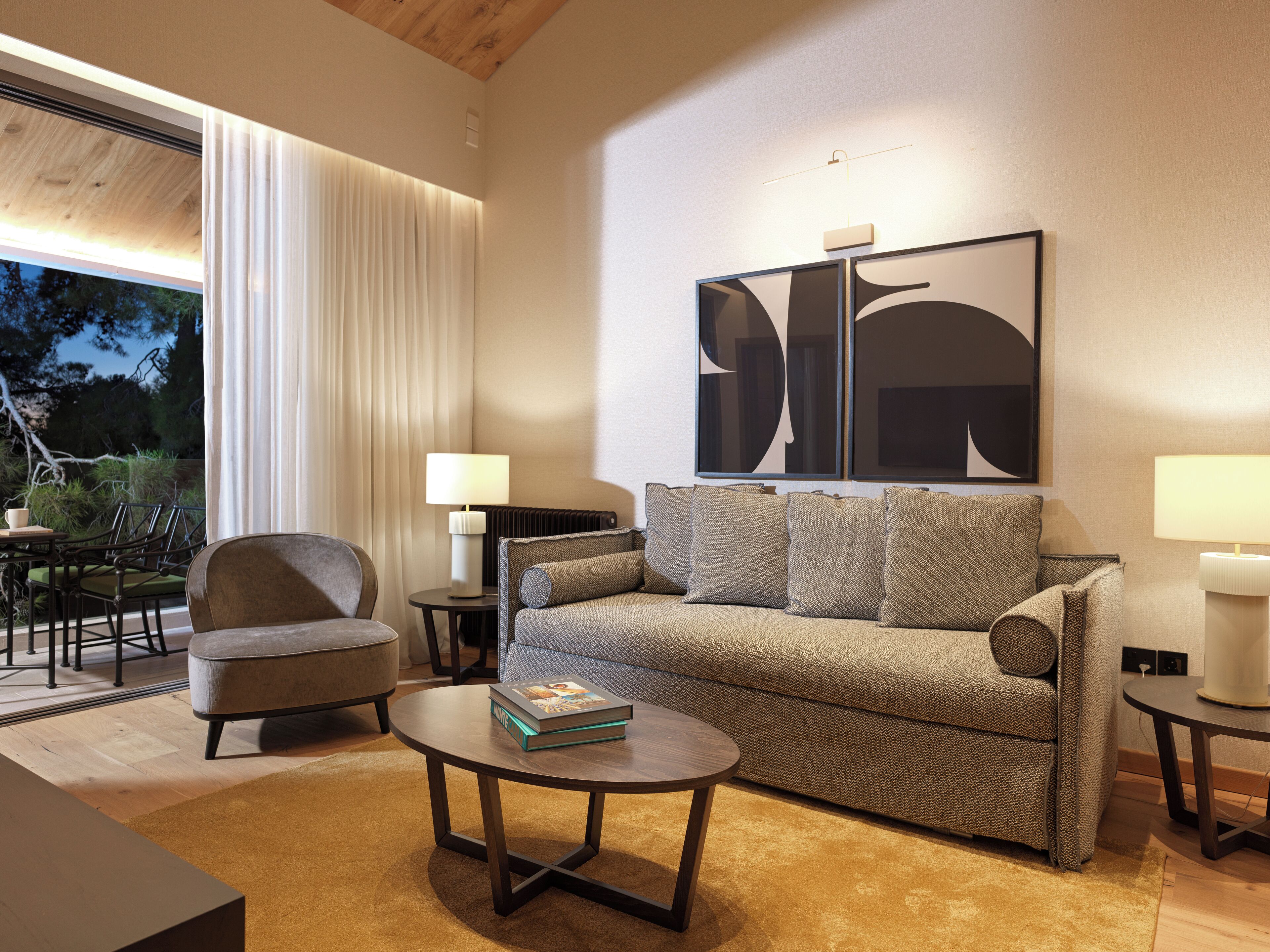 Uma sala de estar moderna com um sofá, poltronas, uma mesa de centro e um grande quadro abstrato na parede.