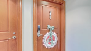 Uma porta de madeira com fechadura eletrônica e interfone.