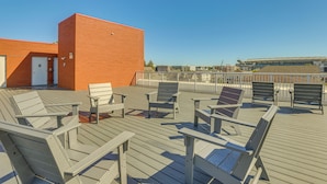 Terraço no telhado com área de estar ao ar livre e vista para um estádio.
