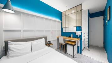 Quarto moderno com cama, escrivaninha e um espelho grande.