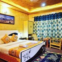 Quarto de decoração rústica com cama, cadeira, mesinha e espelho.