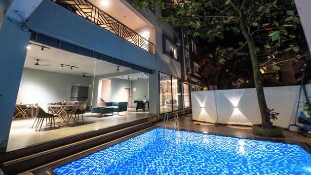 Um edifício moderno com piscina no terraço, área de estar ao ar livre e escadaria para o andar superior.