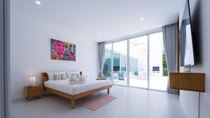 Quarto moderno com uma cama grande, uma televisão de tela plana e uma porta de vidro deslizante para uma varanda.