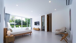 Quarto moderno com uma grande janela, uma cama, uma TV e uma cadeira.