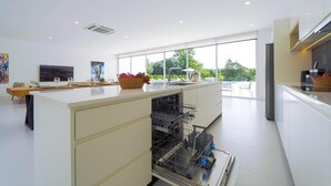 Uma cozinha moderna com ilha central, janelas amplas e vista para o exterior.