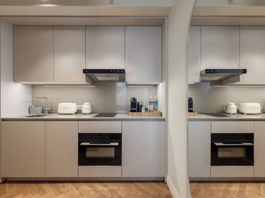 Uma cozinha moderna com dois fornos, um balcão com eletrodomésticos e piso de madeira.