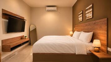 Quarto moderno com cama grande, luminárias de cabeceira, televisão de tela plana e ar condicionado de parede.