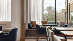 Um interior moderno com áreas de estar, janelas amplas e vista para o exterior.