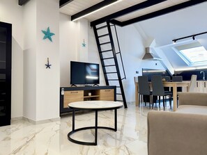 Apartamento família, vista para a cidade | Área de estar | TV