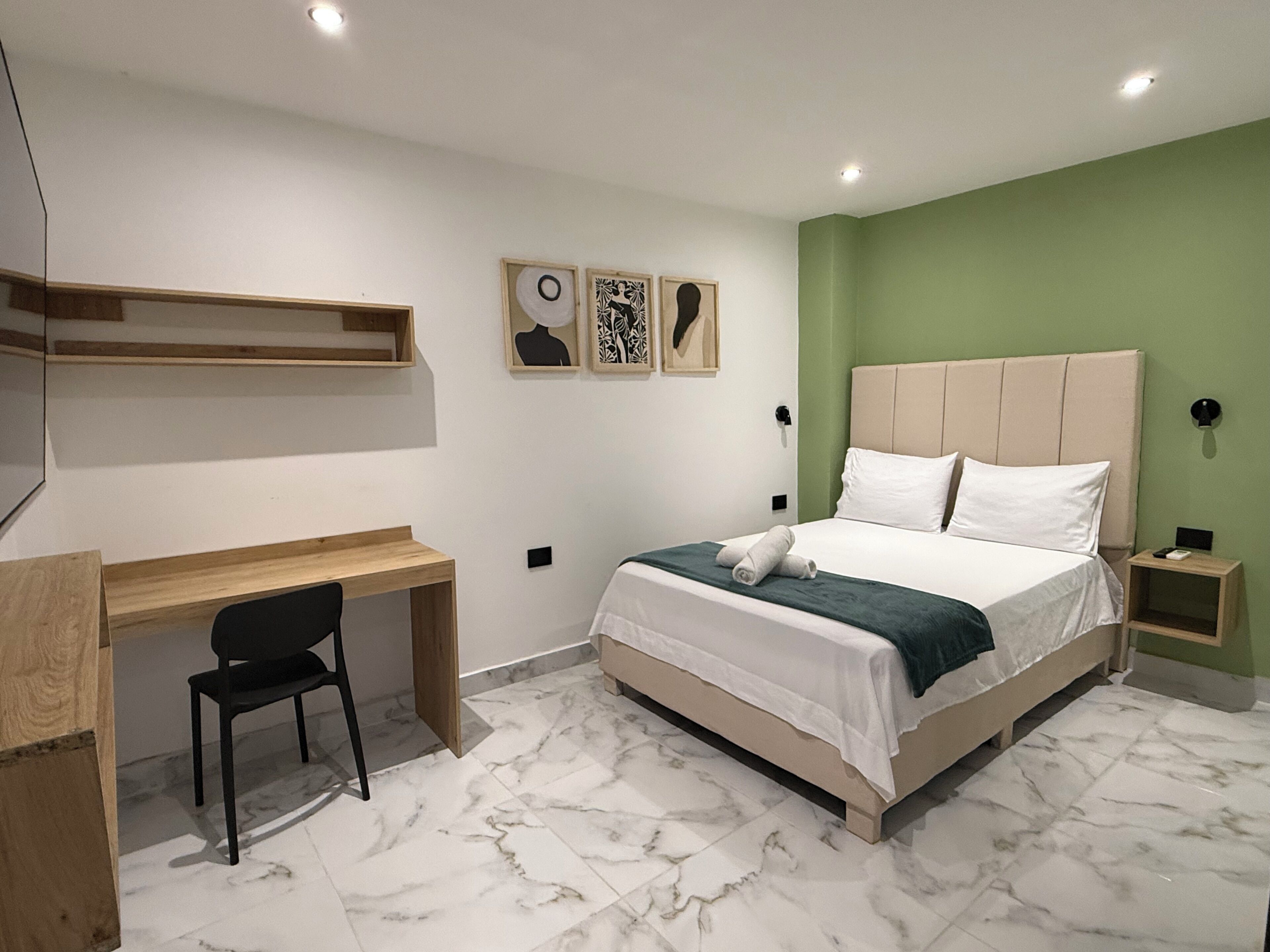 Quarto com cama, escrivaninha e cadeira.