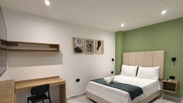 Quarto com cama, escrivaninha e cadeira.