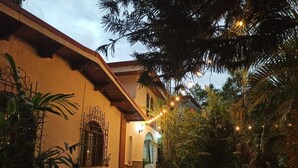Um edifício com varanda, portão e um jardim bem cuidado.