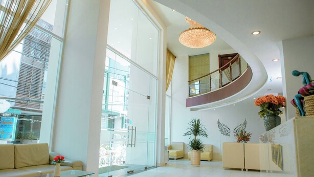 Um hall amplo com uma mesa de centro de vidro, um sofá e um balcão de recepção.