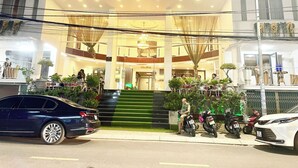 Exterior do Lanxy Hotel, com entrada destacada, escadaria para o saguão e vários veículos estacionados.
