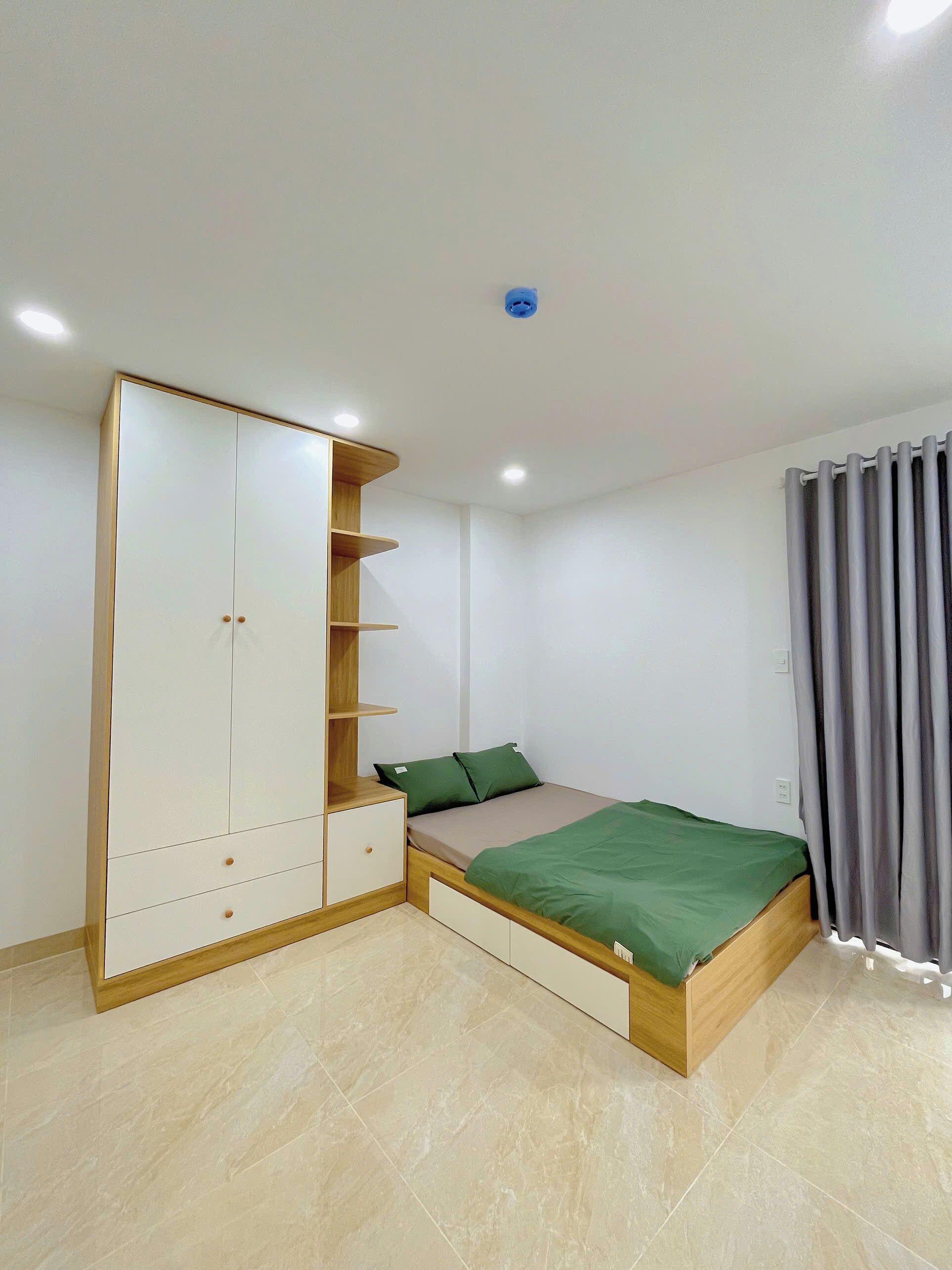 Quarto com cama, guarda-roupa e uma pequena escrivaninha.