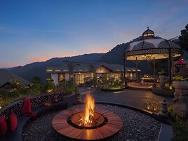 Uma área externa moderna com lareira, um gazebo e um edifício com cúpula.